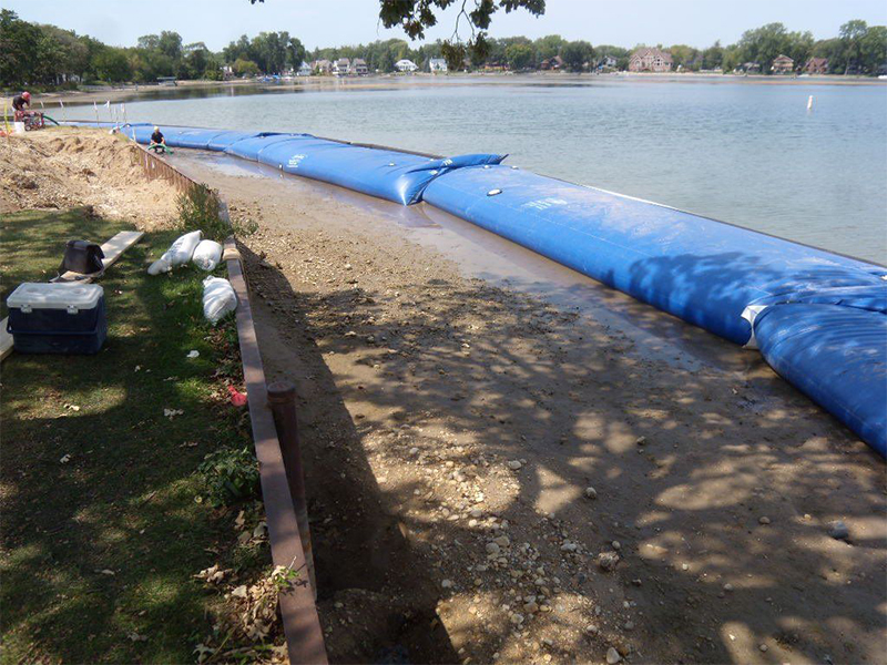 Water filled inflatable flood barrier could be used in construction or ...